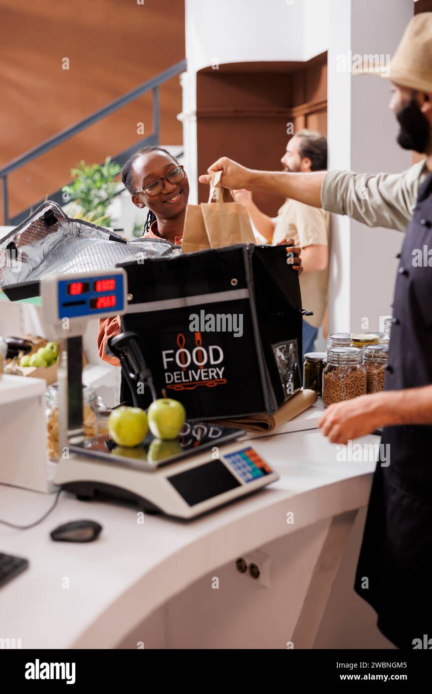 African american lady wearing spectacles accepts packaged groceries ...
