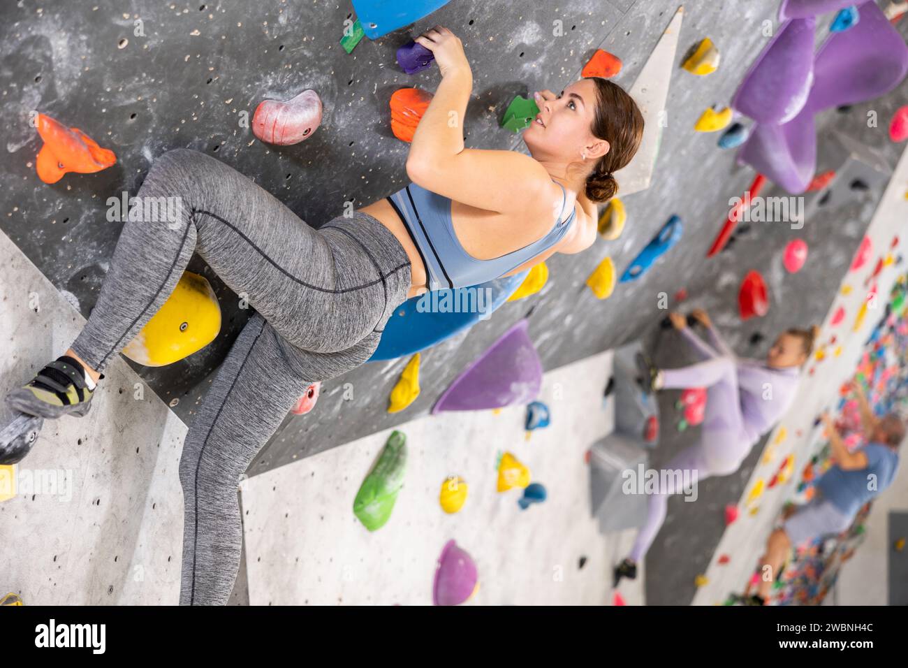 Young woman practicing rock climbing on climbing wall Stock Photo - Alamy