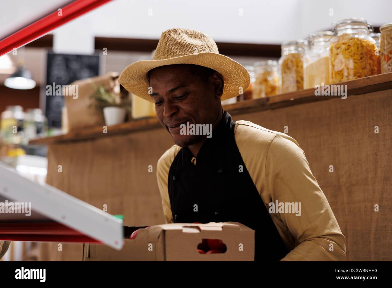 Detailed image shows a black man wearing an apron organizing a variety ...