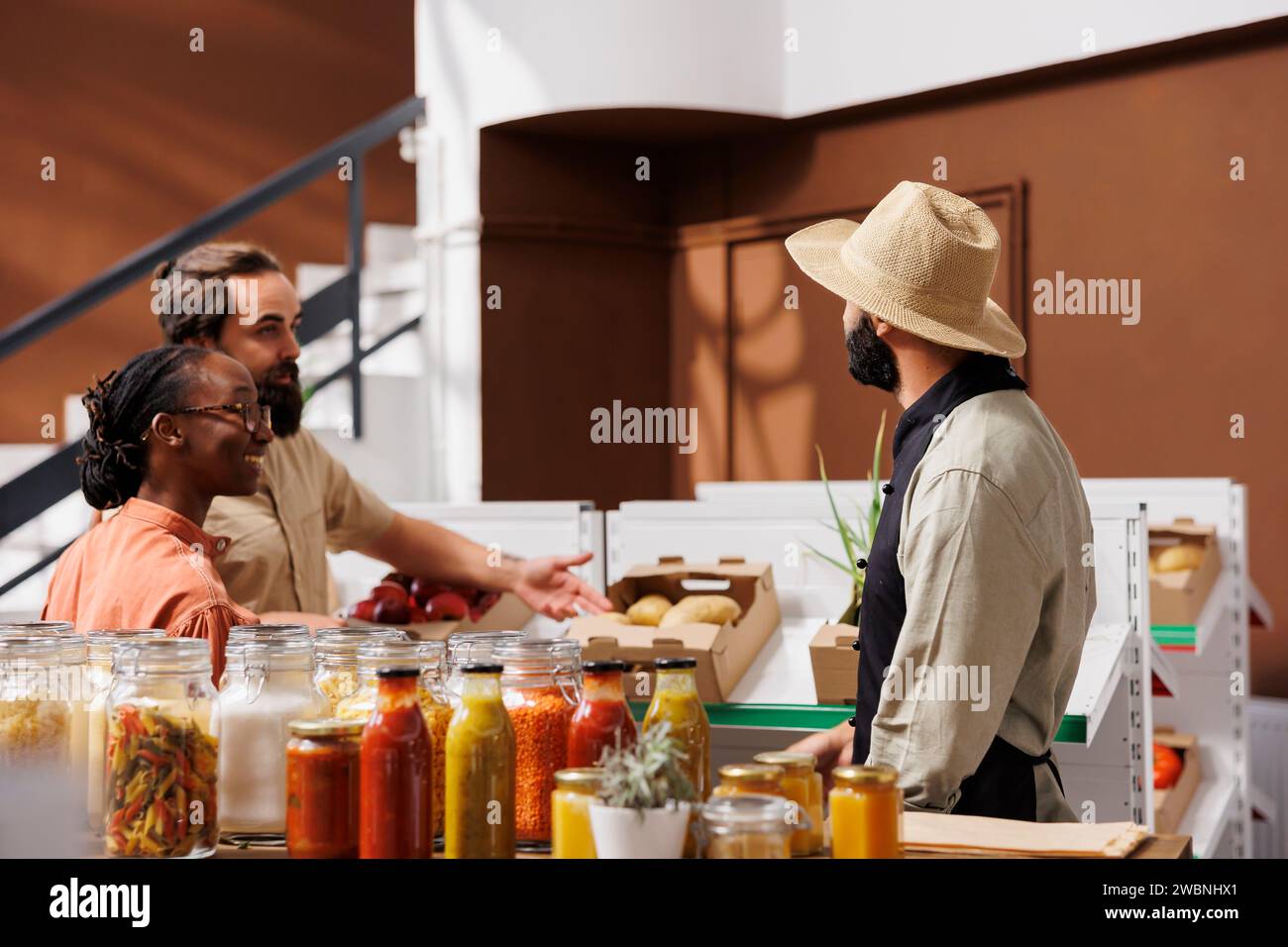Merchant with a hat showing freshly harvested produce to young husband ...
