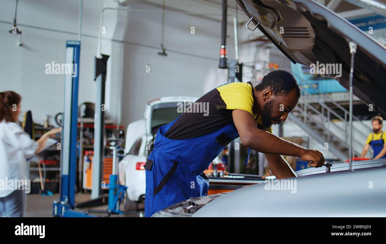 Trained technician in car service picks torque wrench from work station ...