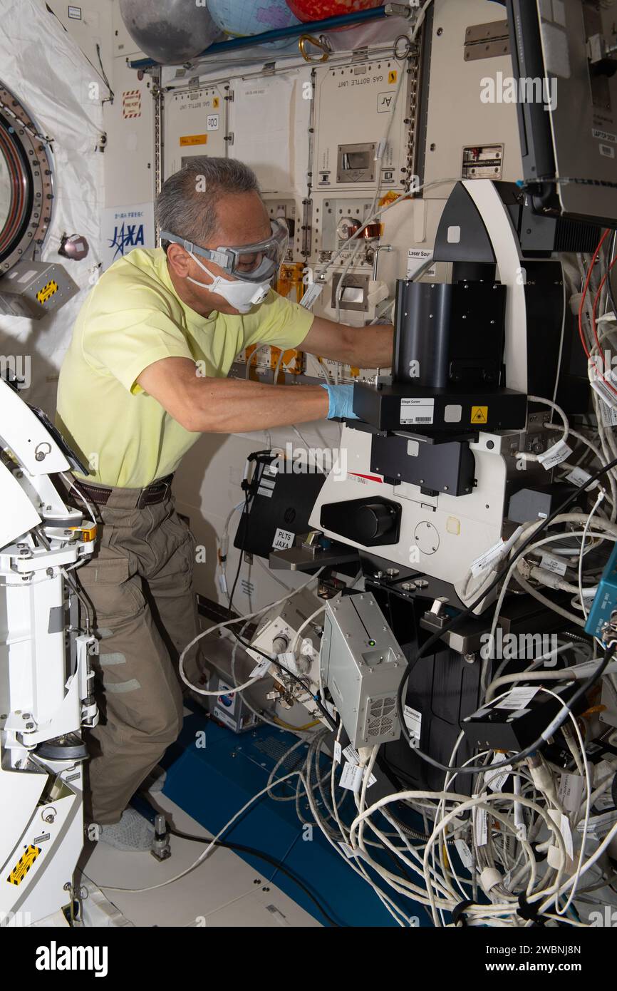 JAXA astronaut Satoshi Furukawa operates a microscope and removes ...