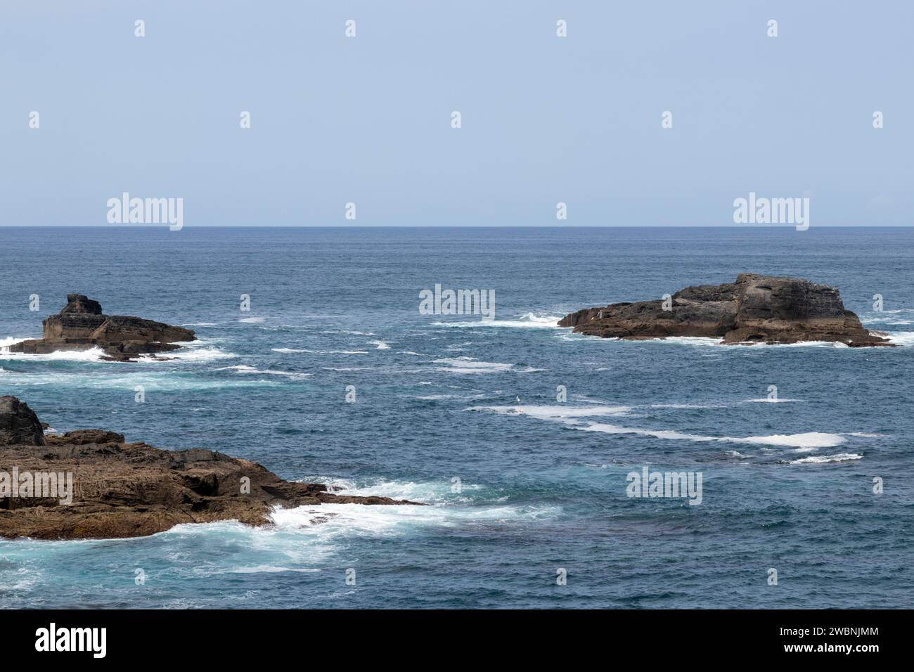 serene yet dynamic seascape with rocky outcrops amidst turbulent ocean ...