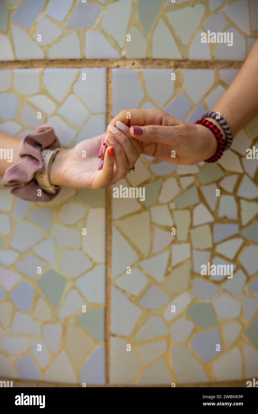 Two female hands holding over mosaic of Park Guell by Gaudi in ...