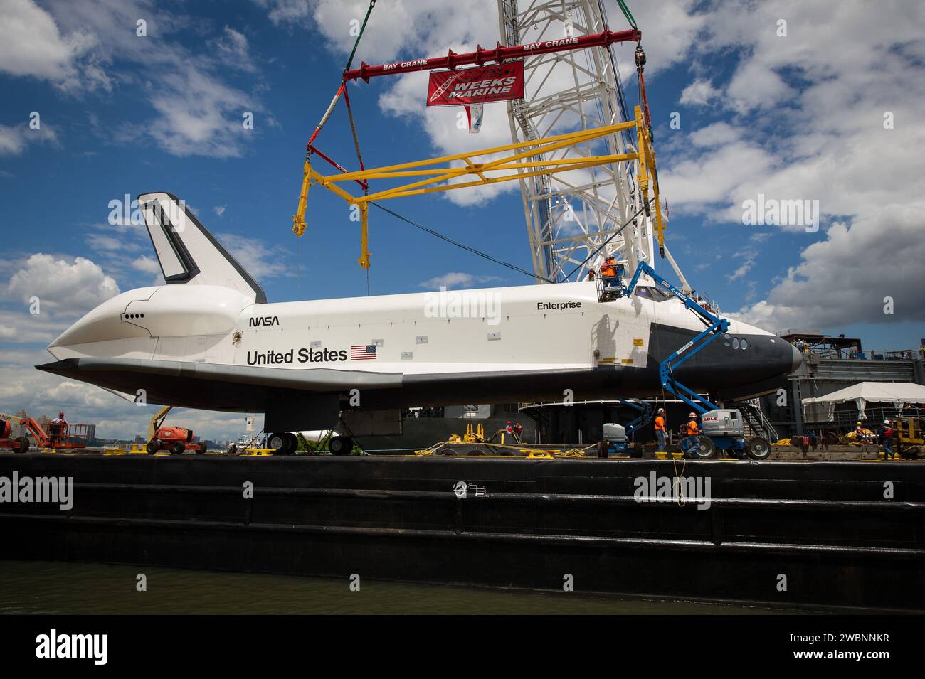 Workers prepare to attach a sling to the space shuttle Enterprise in ...