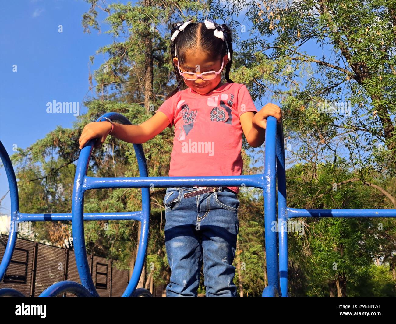 4 year old Latina brunette girl plays in the park games under the sun ...