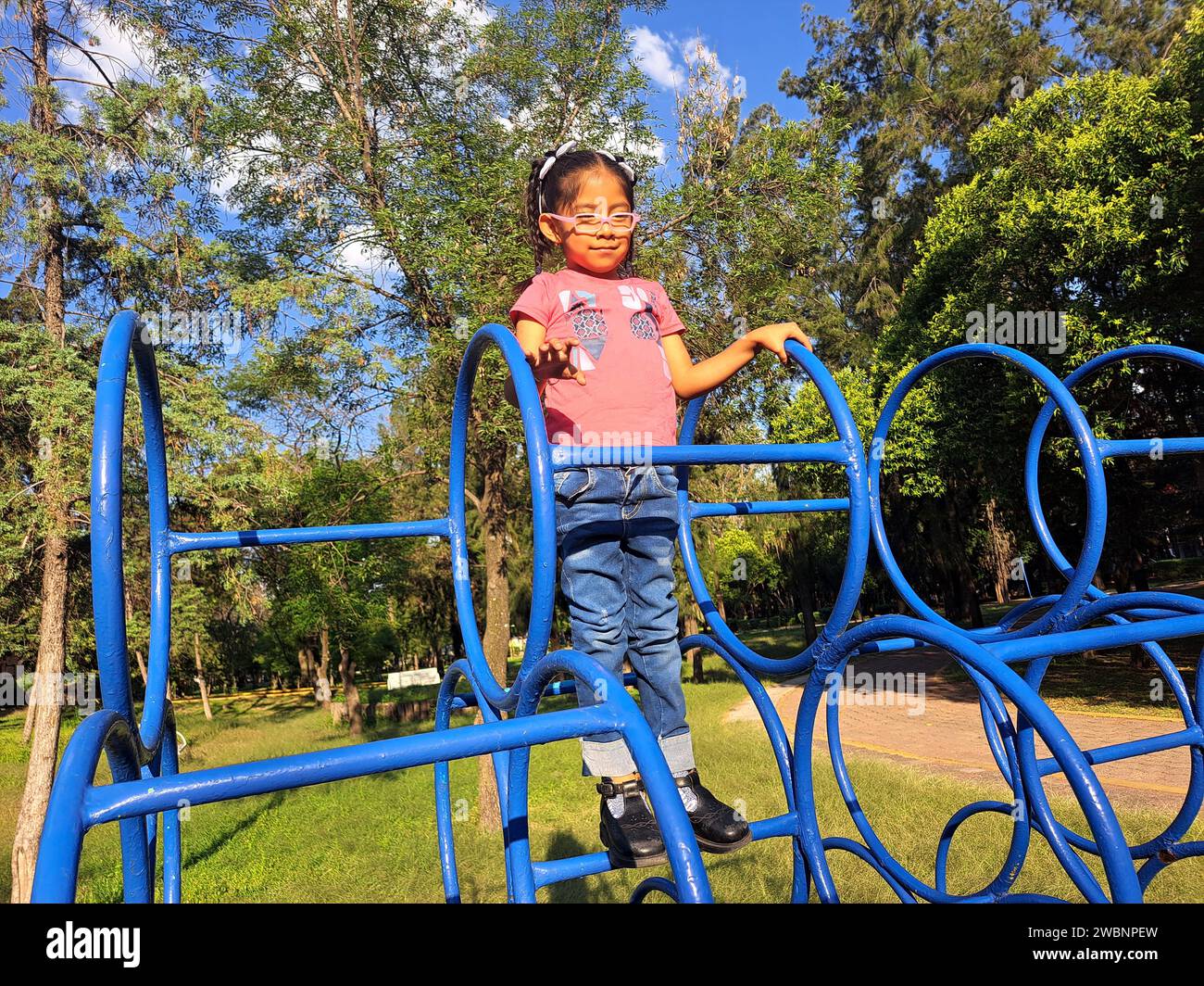 4 year old Latina brunette girl plays in the park games under the sun ...