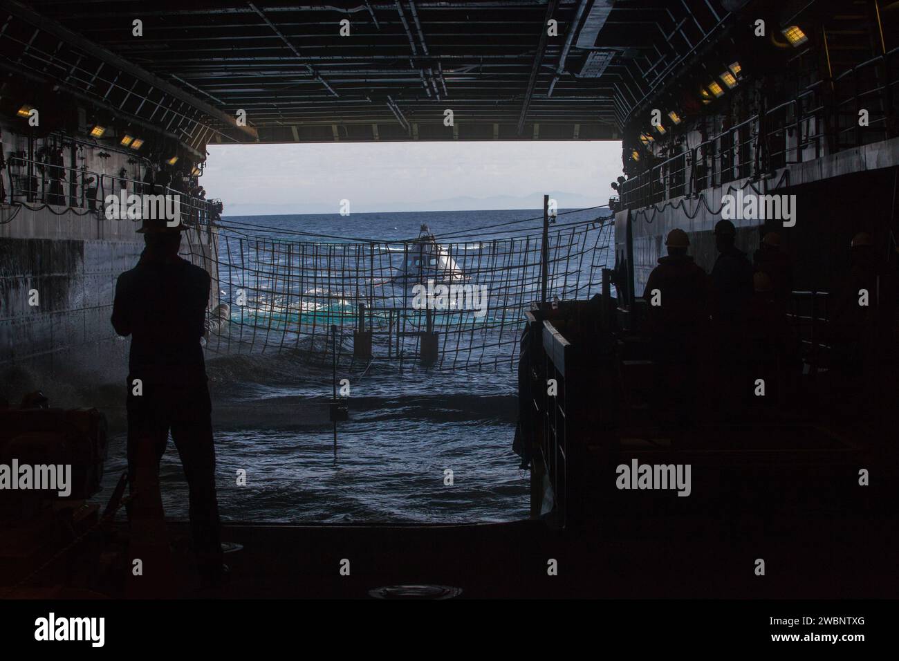 A test version of the Orion crew module floats outside the well deck of ...
