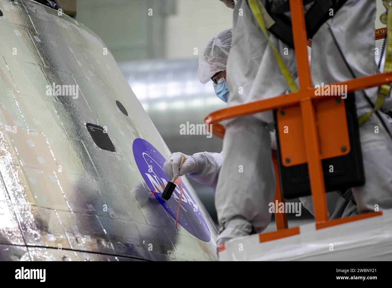 Frank Pelkey, ASRC technician, paints a clear adhesive over the NASA ...