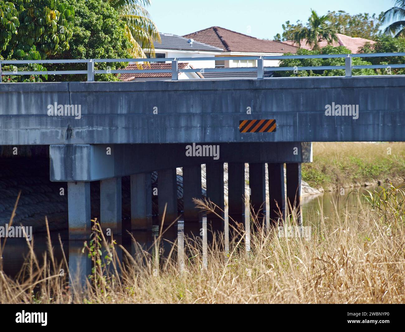 Low road bridge over a canal in Miami, Florida, with warning sign of ...