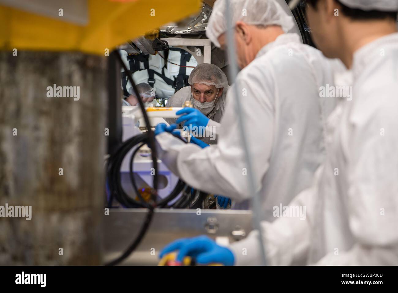 Mission engineers prepare the final cargo before loading it into the ...