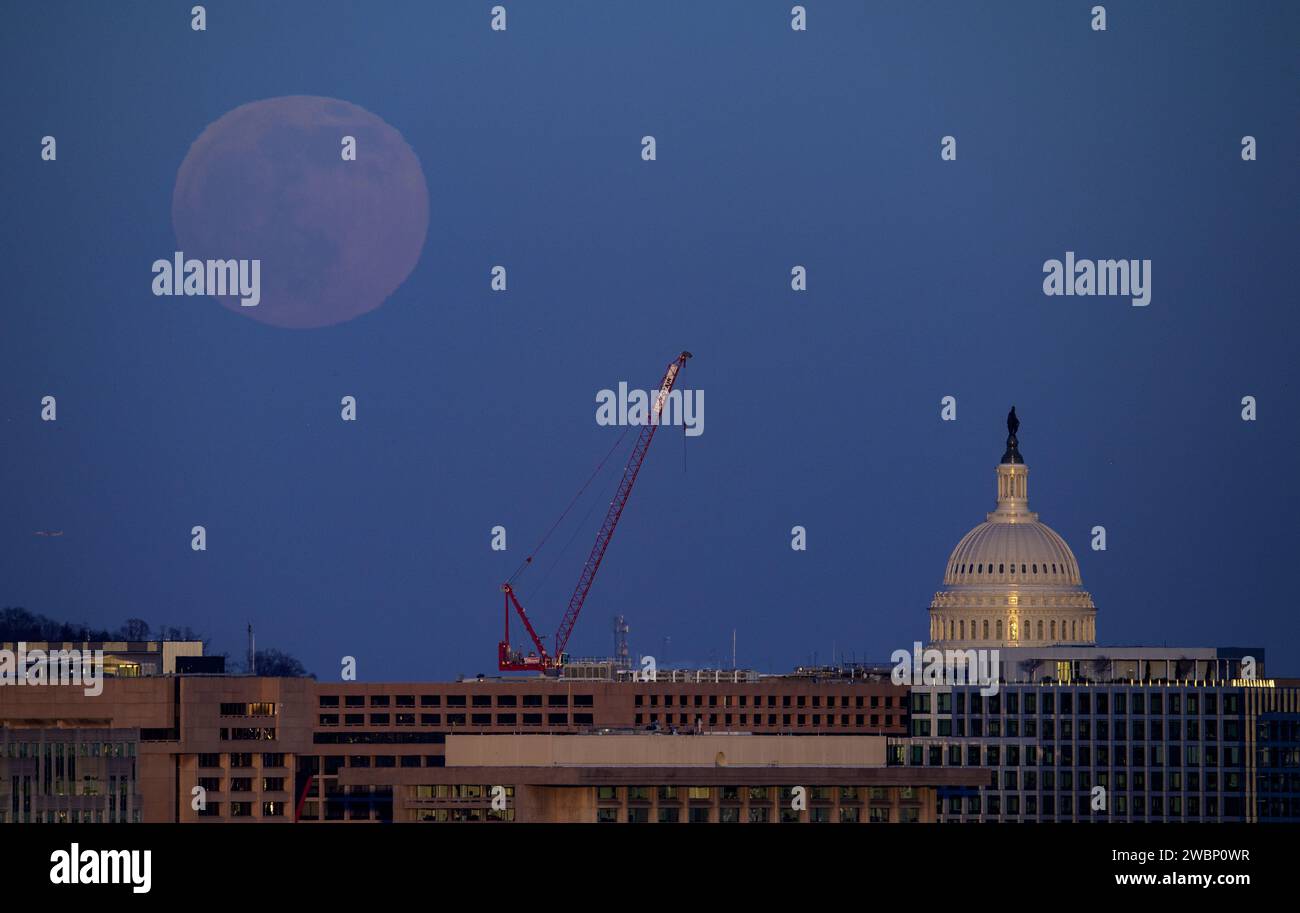 The full Moon rises behind the U.S. Capitol in Washington, D.C., on ...