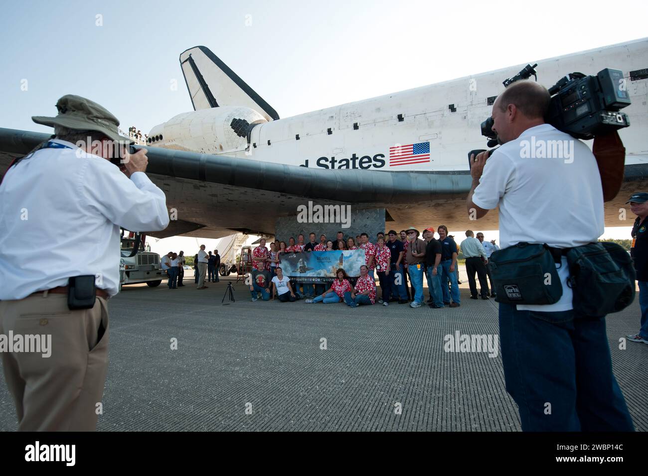 NASA and contractor personnel are photographed under the wing of the space shuttle Atlantis at ...