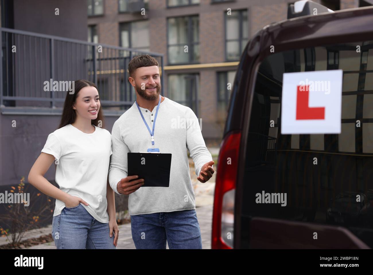 Learner driver and instructor near car with L-plate outdoors. Driving ...
