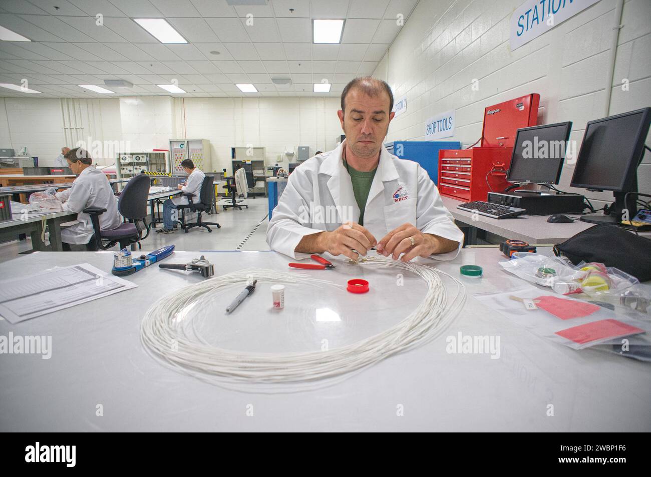 Technicians work on the harness assembly for the Exploration Flight ... Technicians work on the harness assembly for the Exploration Flight ...