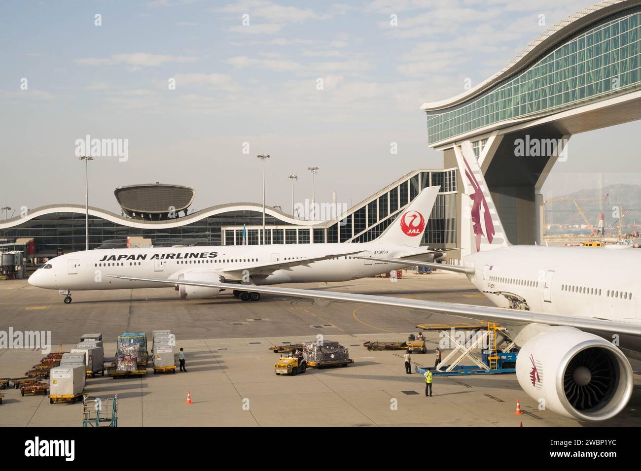 Japan airlines' aircraft driving on tarmac apron underneath sky bridge ...