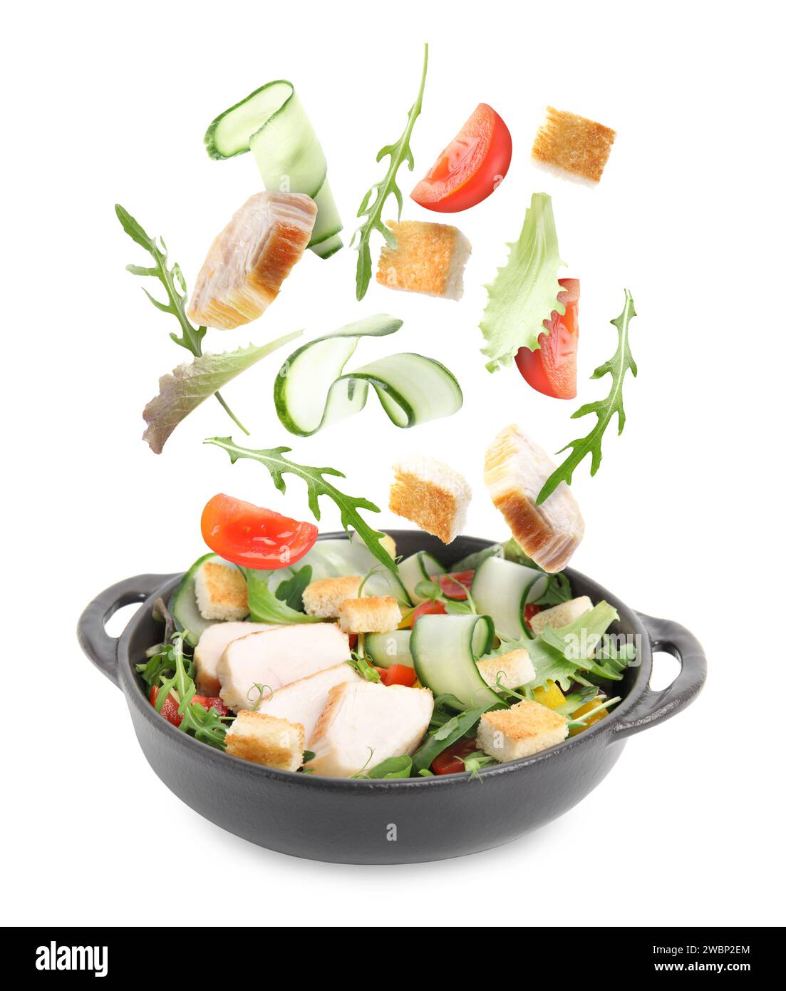 Ingredients falling into dish with tasty salad on white background ...