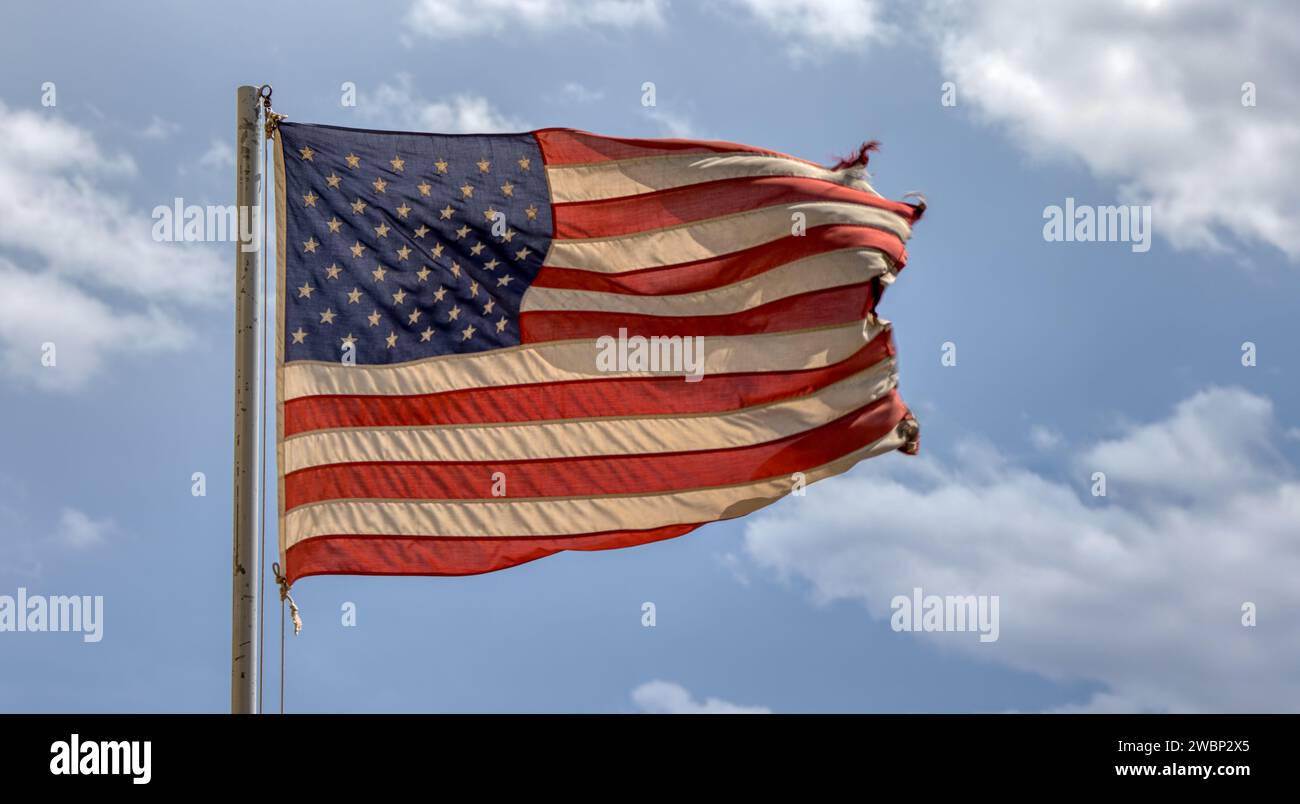american flag tear up on the pole, blue sky with clouds Stock Photo - Alamy