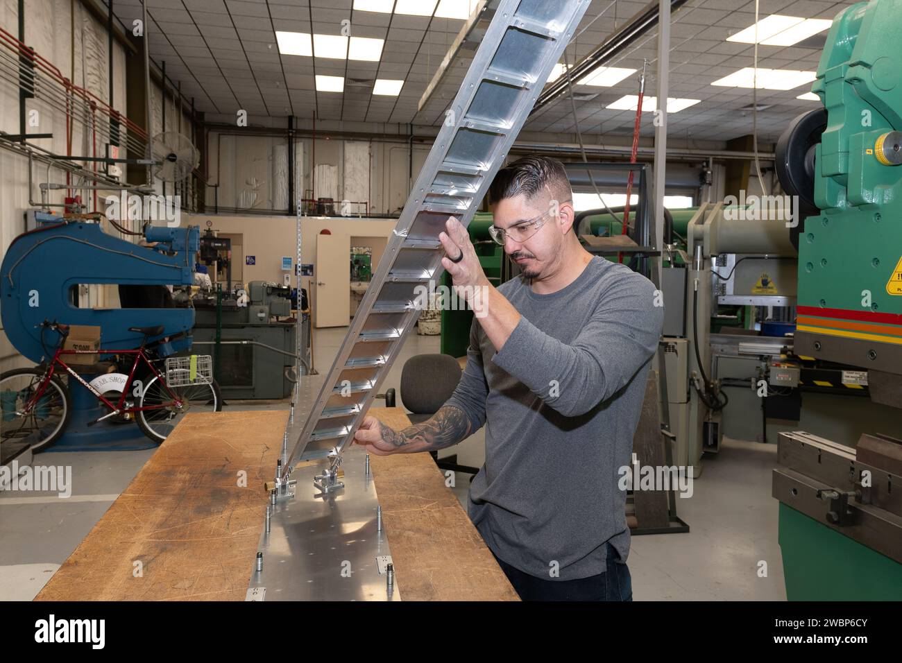 Matthew Sanchez attaches the strut and the wing to ensure they fit ...