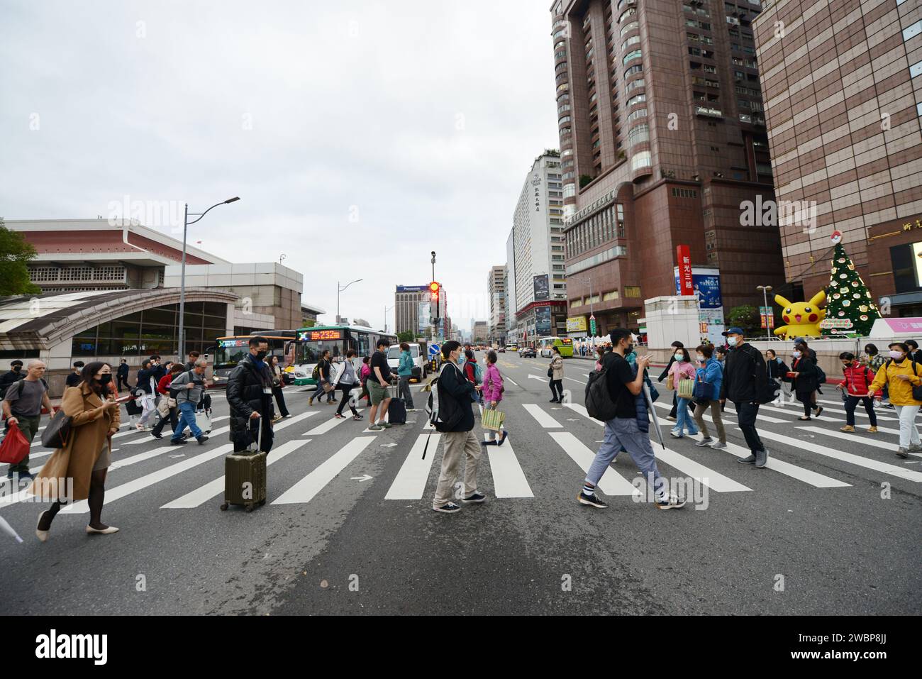 Pedestrians crossing the road opposite the Taipei Main station in ...