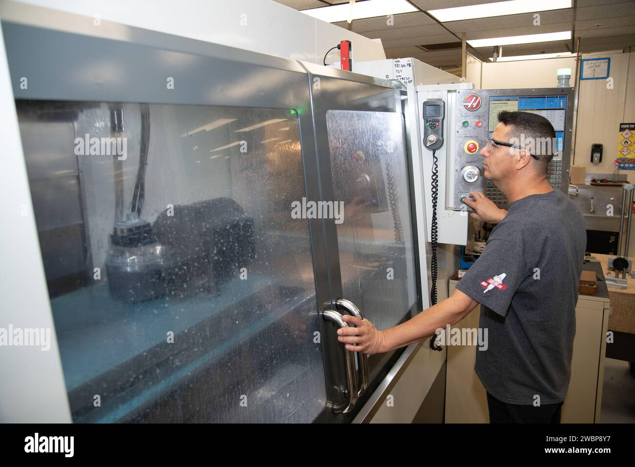 Jose Vasquez uses a machine to cut, rotate and turn a block of aluminum ...