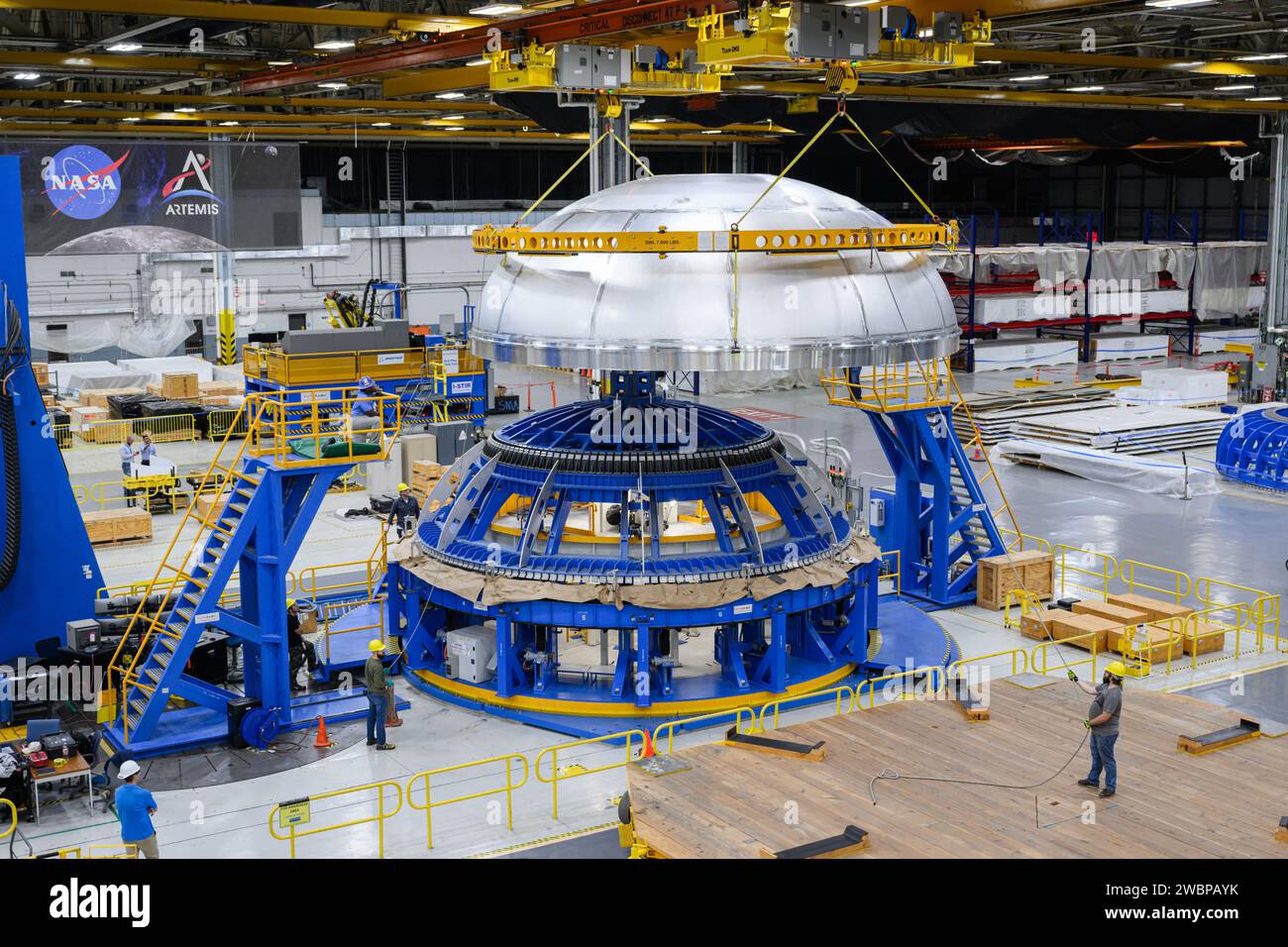 Technicians at NASA’s Michoud Assembly Facility move the aft dome of ...