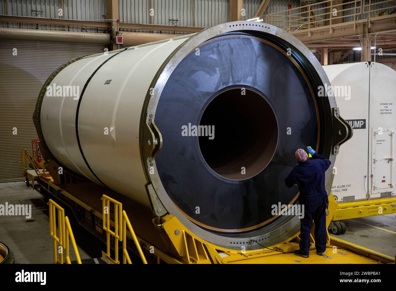 Engineers and technicians process and inspect the propellant of the right forward center segment ...