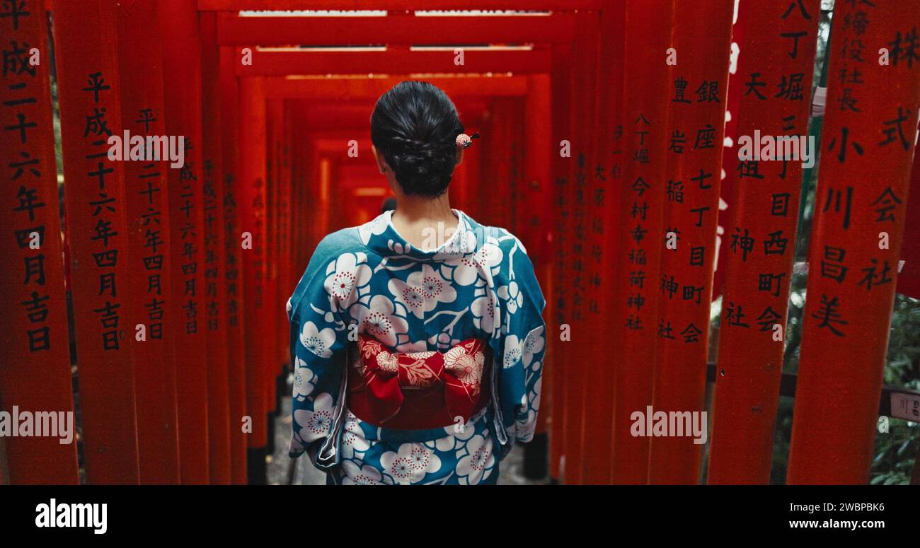 Woman, shinto religion or back by gates in japan, spiritual path or ...