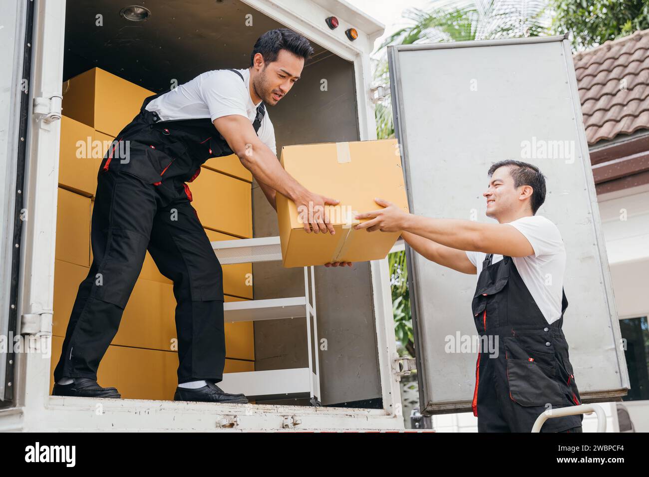 Teamwork in action, removal service workers unload boxes and furniture ...