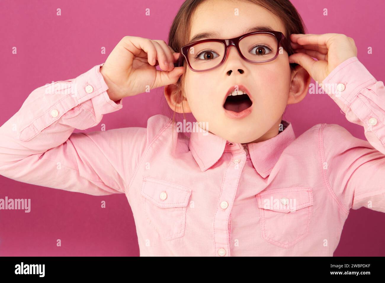 Portrait, shocked and girl child with glasses in studio isolated on a ...