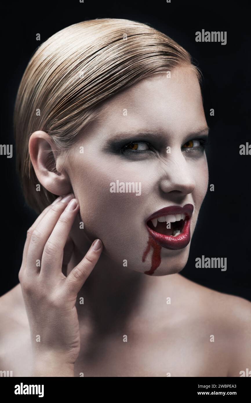 Portrait, blood and a female vampire in studio on a dark background for ...