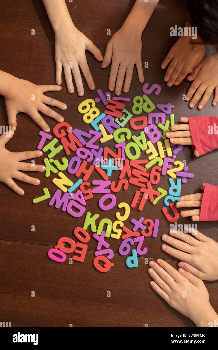 Kids learning toy numbers, preparing to school. Top view of kids hands ...