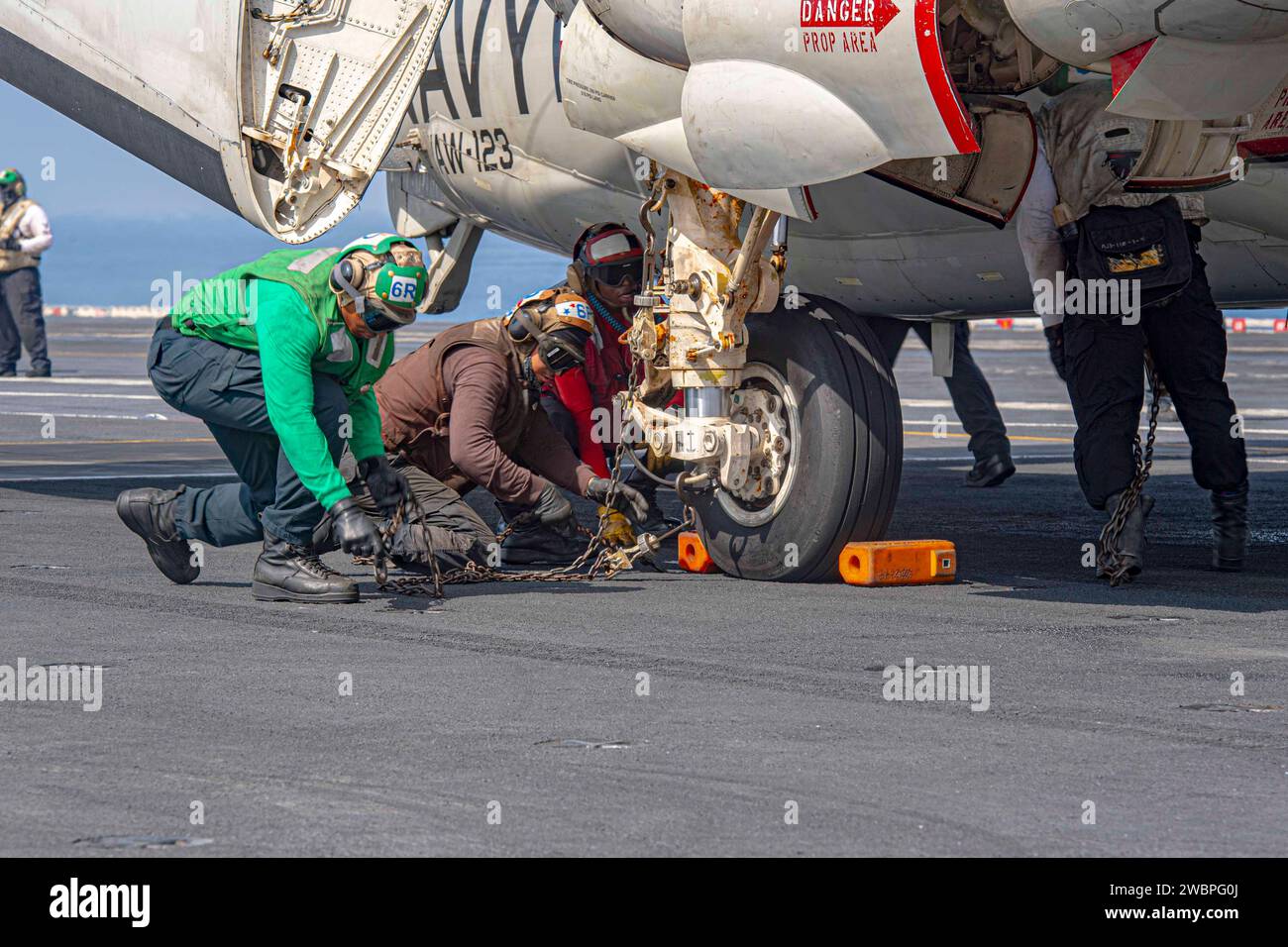 U.S. Navy Sailors secure an E-2C Hawkeye, attached to the "Screwtops ...