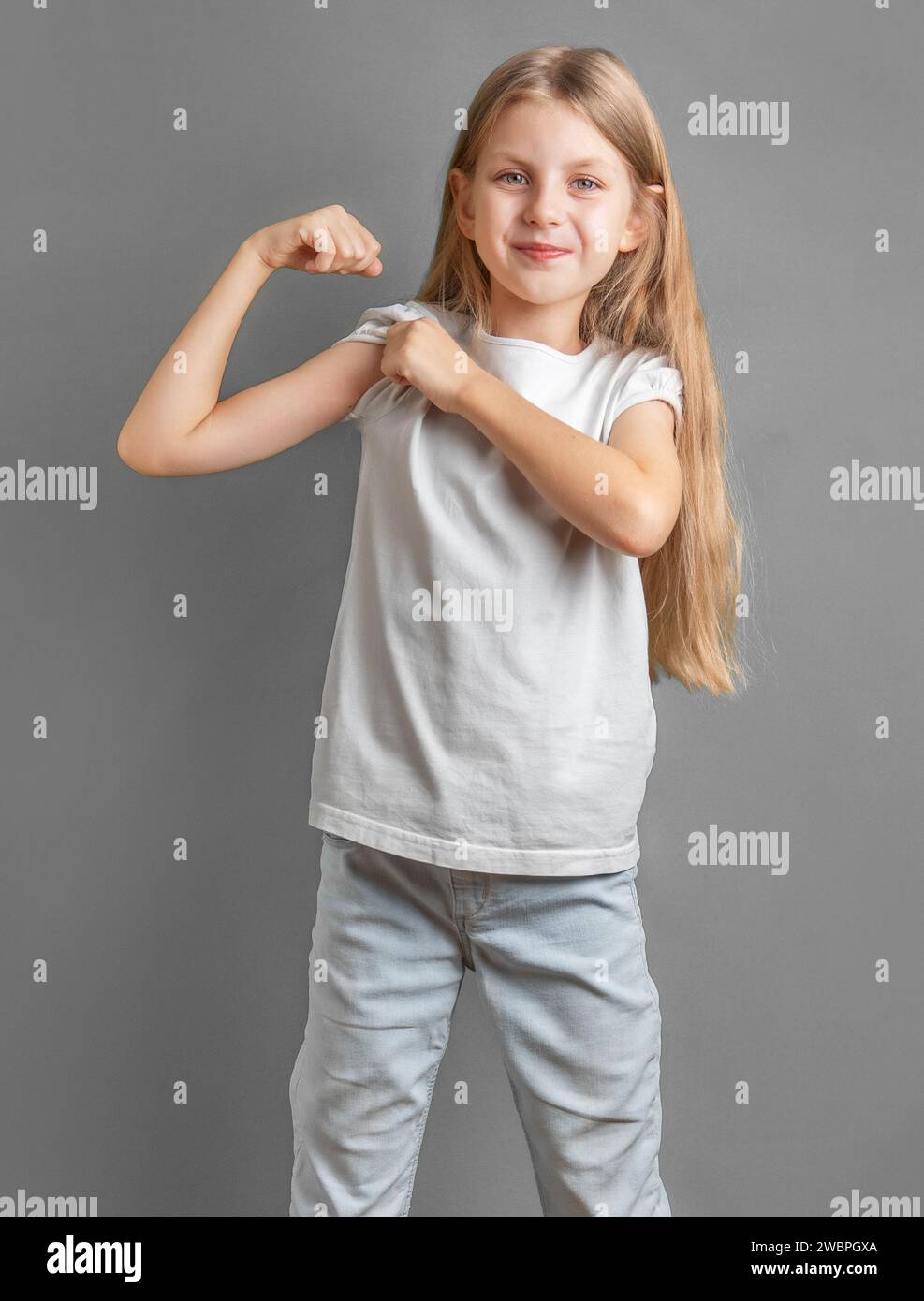 Cute girl showing biceps hi-res stock photography and images - Alamy