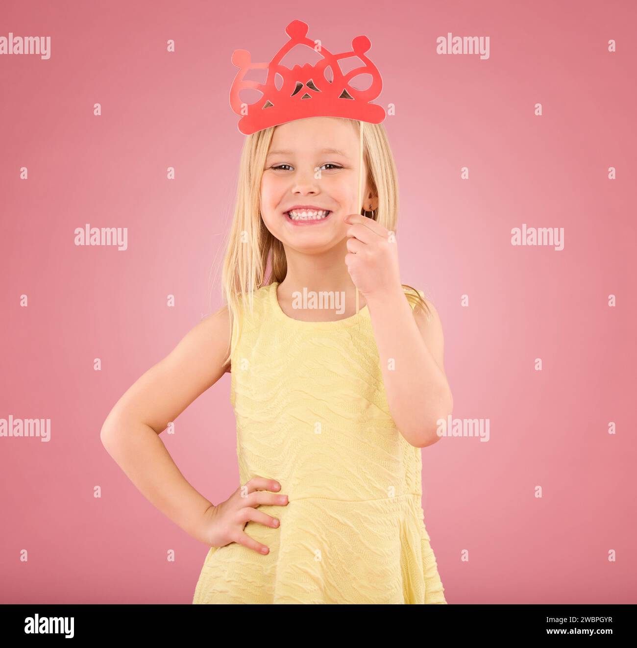 Girl, child and smile portrait with a crown in studio on a pink ...