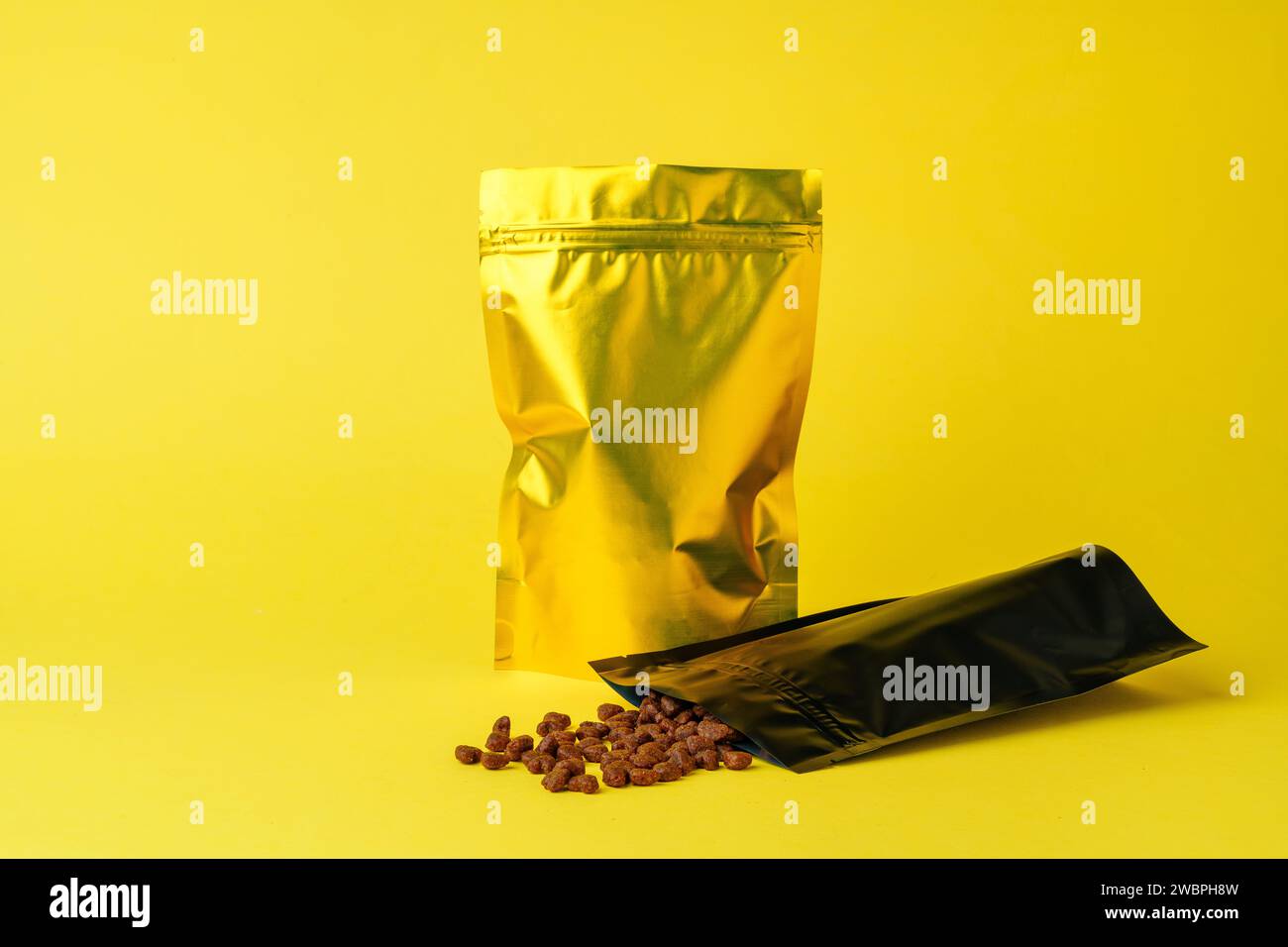 Cat food on yellow background studio shot Stock Photo - Alamy