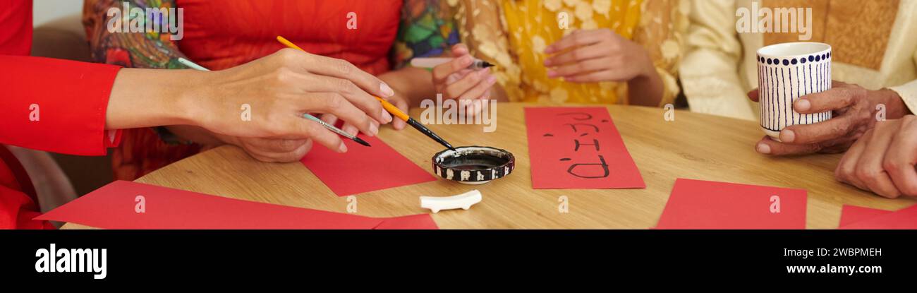 Header with hands of family members creating calligraphy couplets for ...