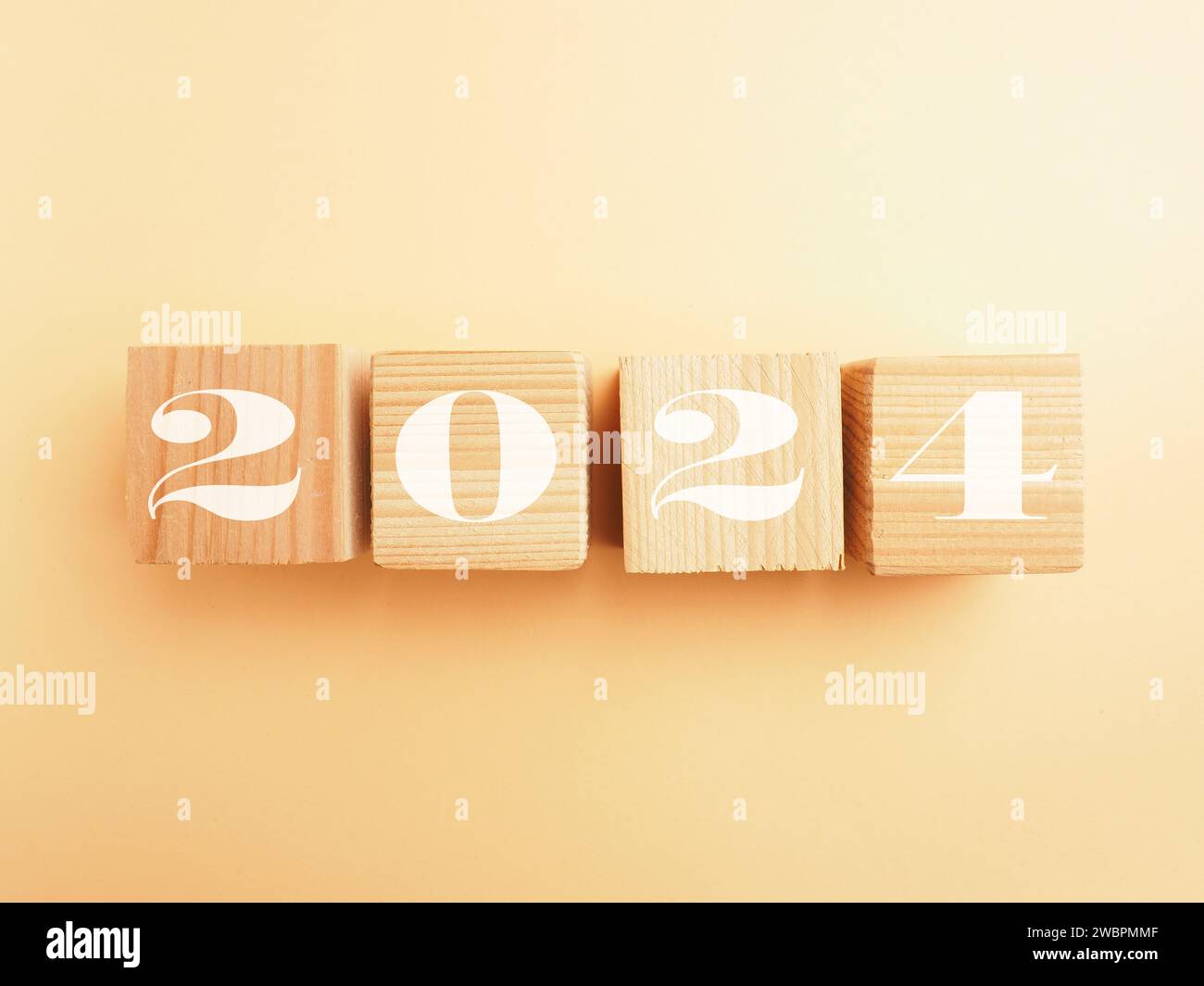 Wooden blocks with the Year number 2024 on a peach colored background ...