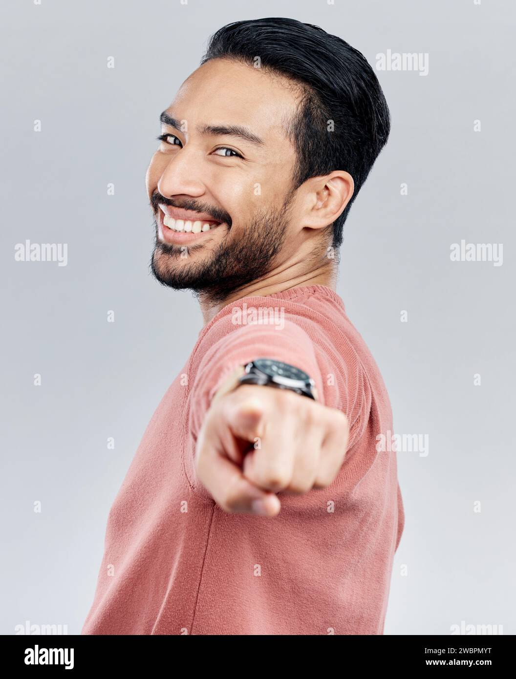 Pointing, happy and smile with portrait of man in studio for thank you ...