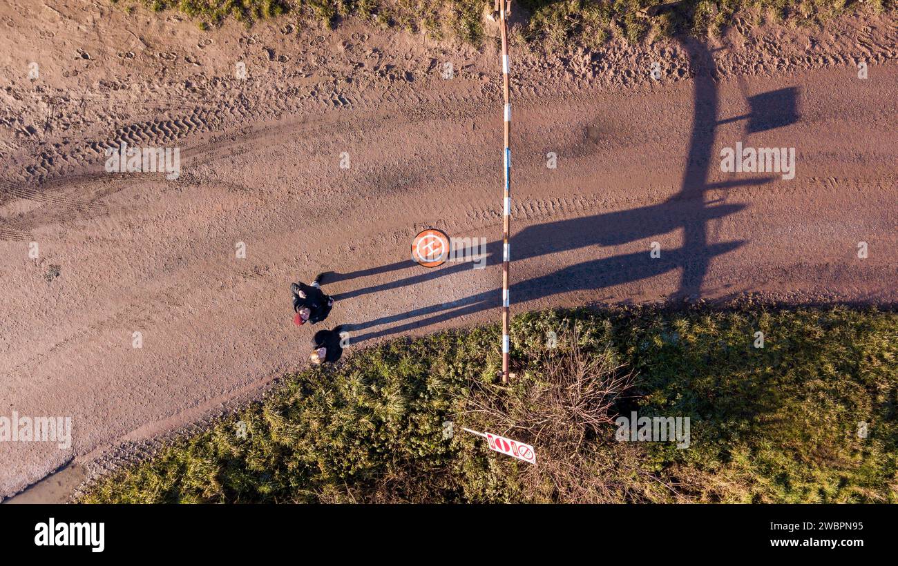 This aerial image captures a solitary figure at a crossroads, the long ...