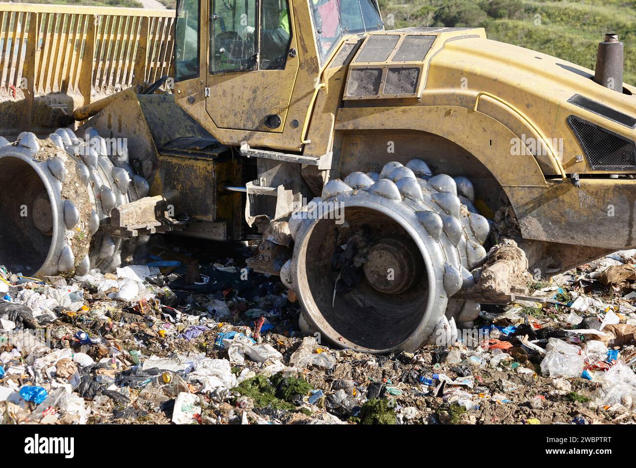 Heavy machinery shredding garbage in an open air landfill. Waste Stock ...