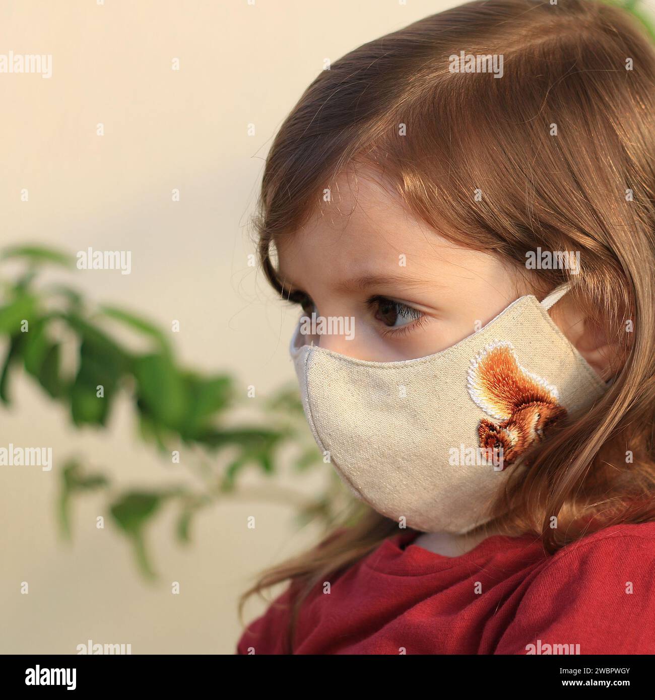 A long-haired toddler wearing a face mask during the Covid-19 pandemic ...