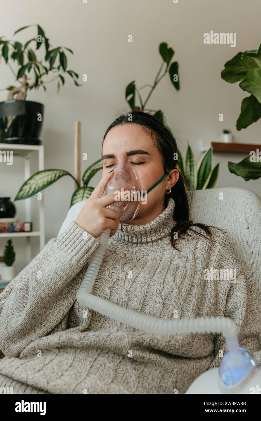 A young woman wearing a respiratory mask to facilitate proper breathing ...