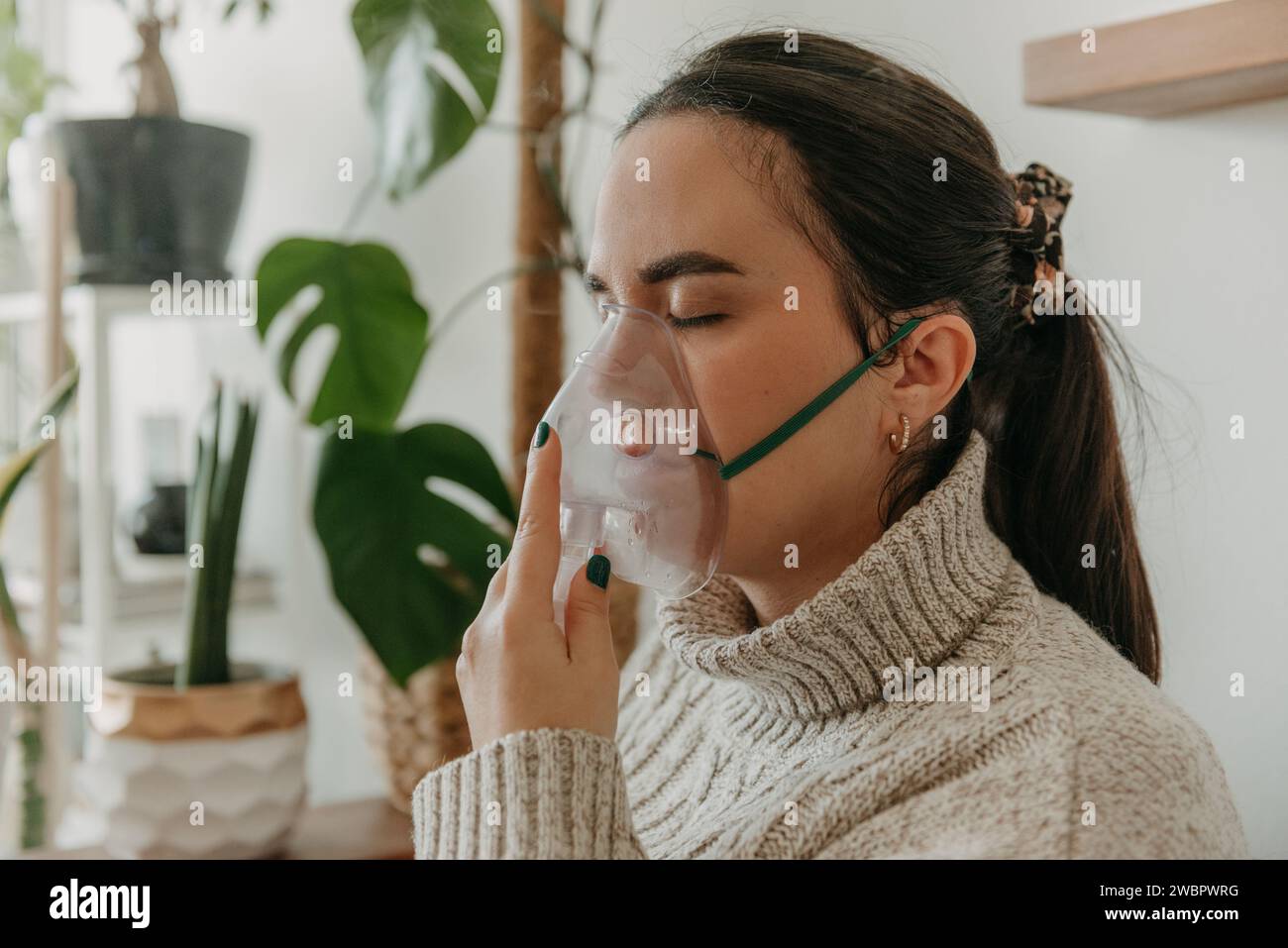 A young woman wearing a respiratory mask to facilitate proper breathing ...