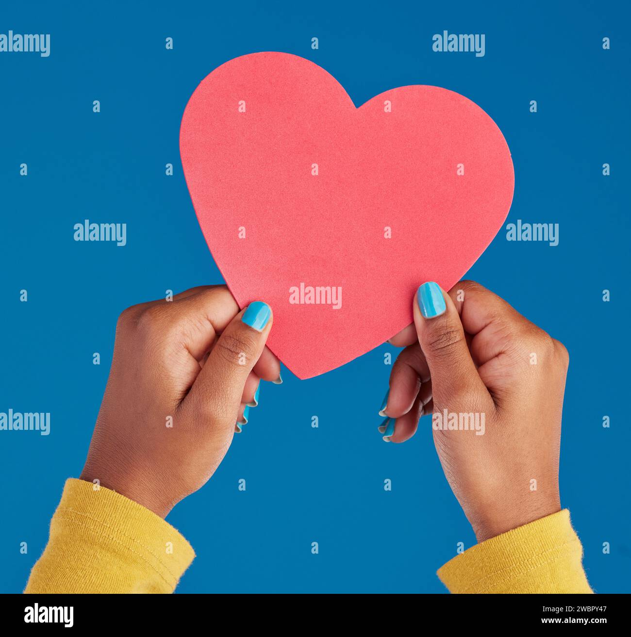 Paper, heart and hands of black woman in studio for love, date and ...