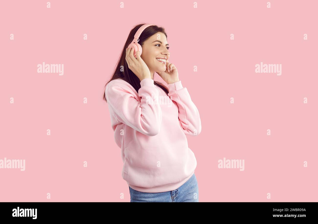 Happy young woman enjoys listening to music in modern wireless stereo ...