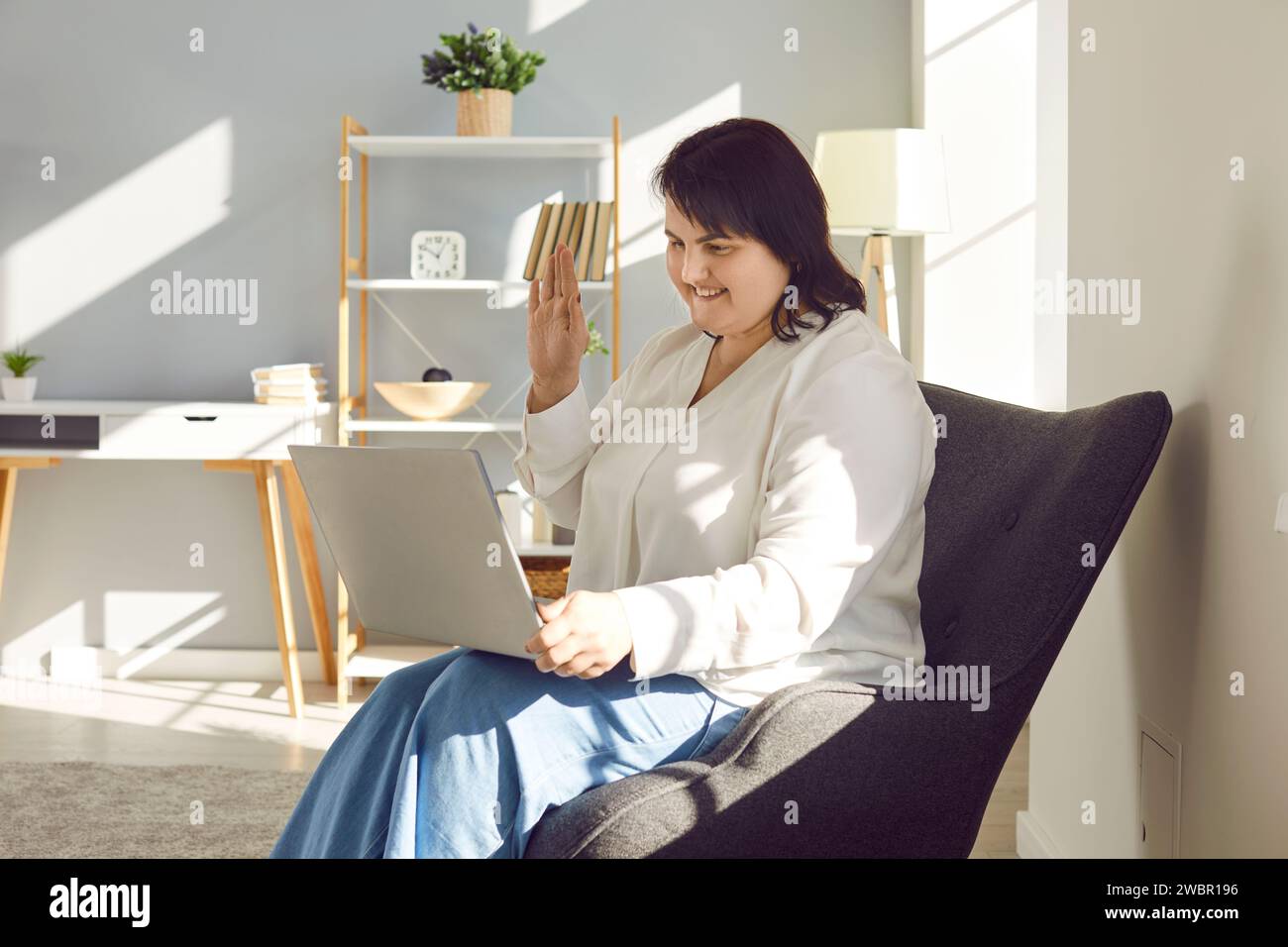 Fat overweight smiling woman sitting on the chair at home having video ...