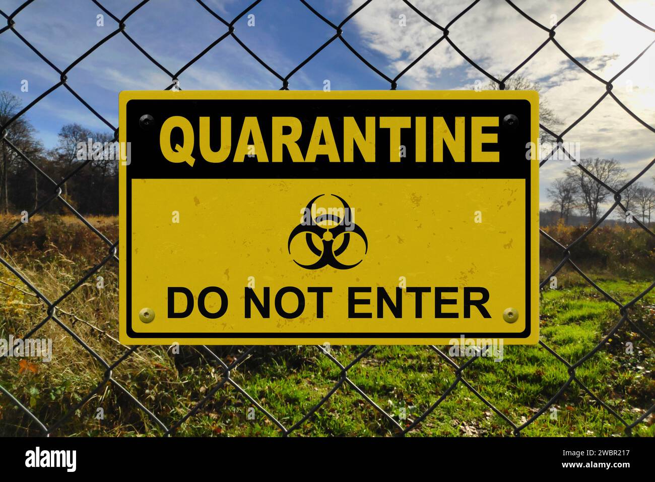 Black and yellow warning sign on a fence displaying a biohazard symbol ...