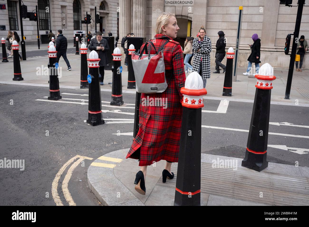 City workers walk past new street bollards after a widening of the ...