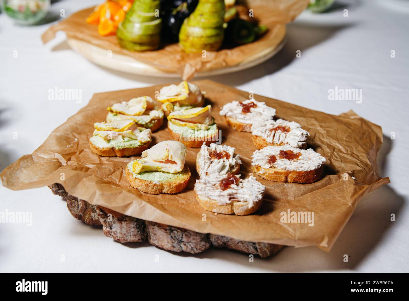 Delicious variety of canapes with toppings on a rustic wooden board ...